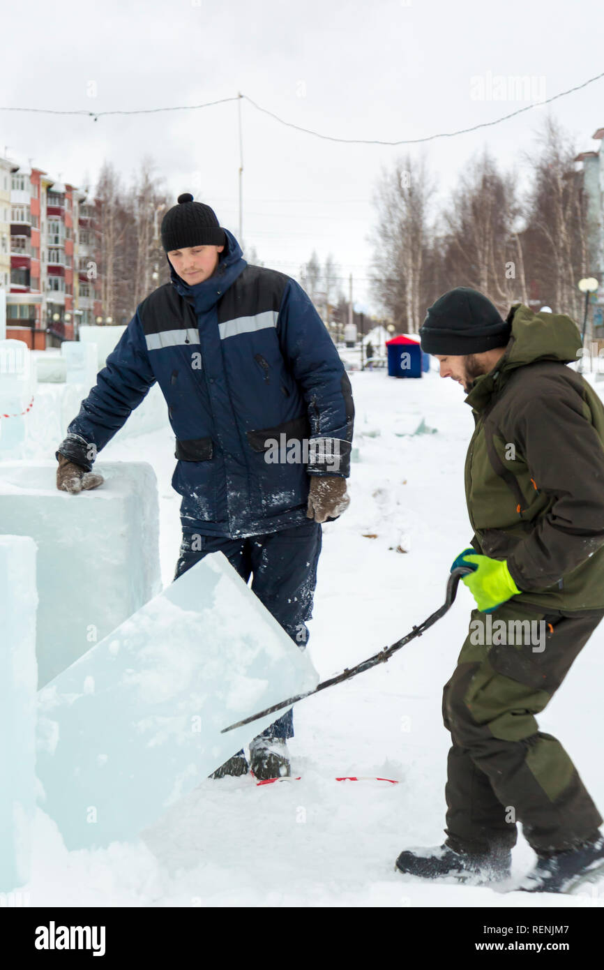 The worker pulls the ice block around the ice camp assembly site with ...