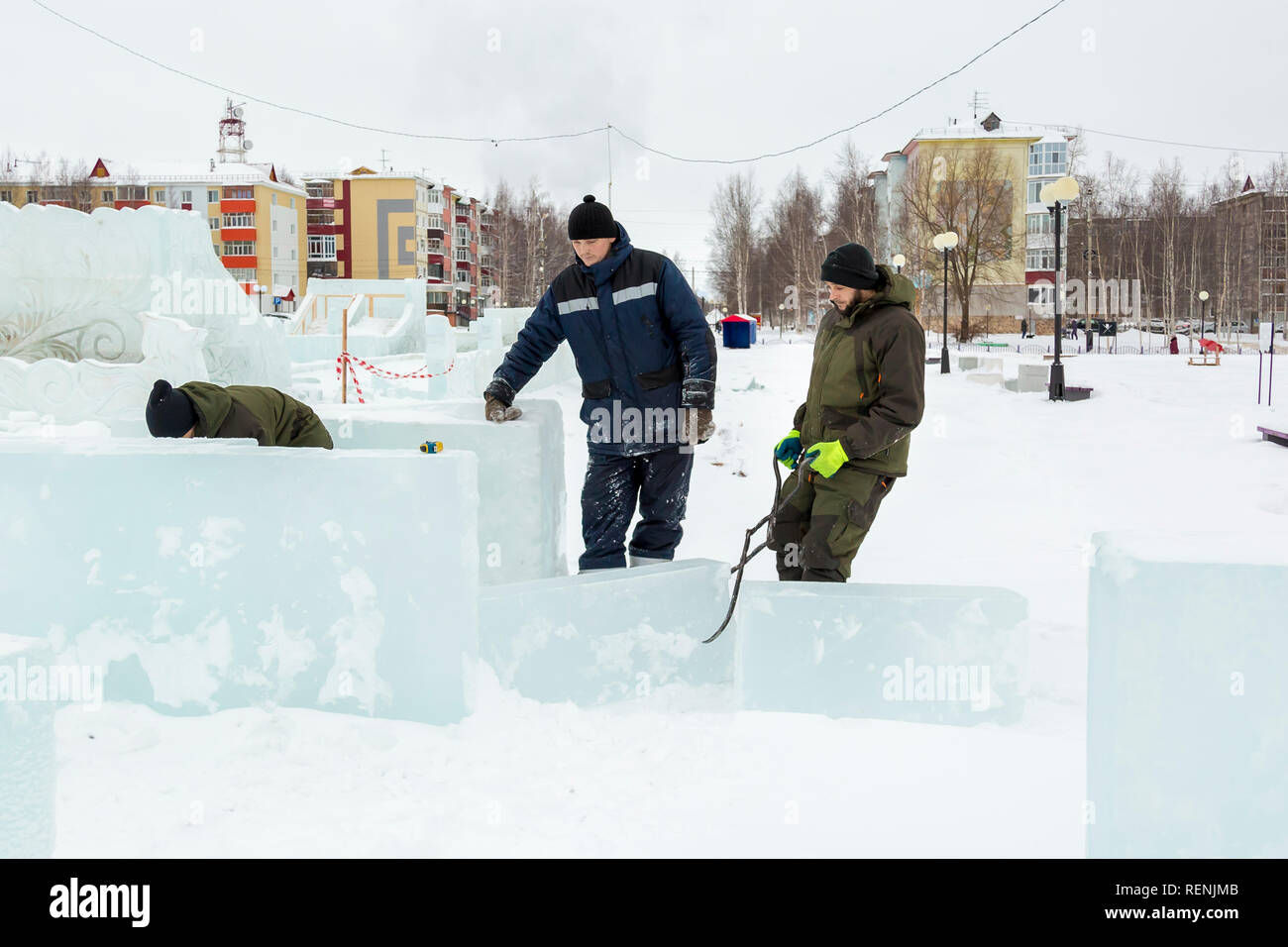 The worker pulls the ice block around the ice camp assembly site with ...