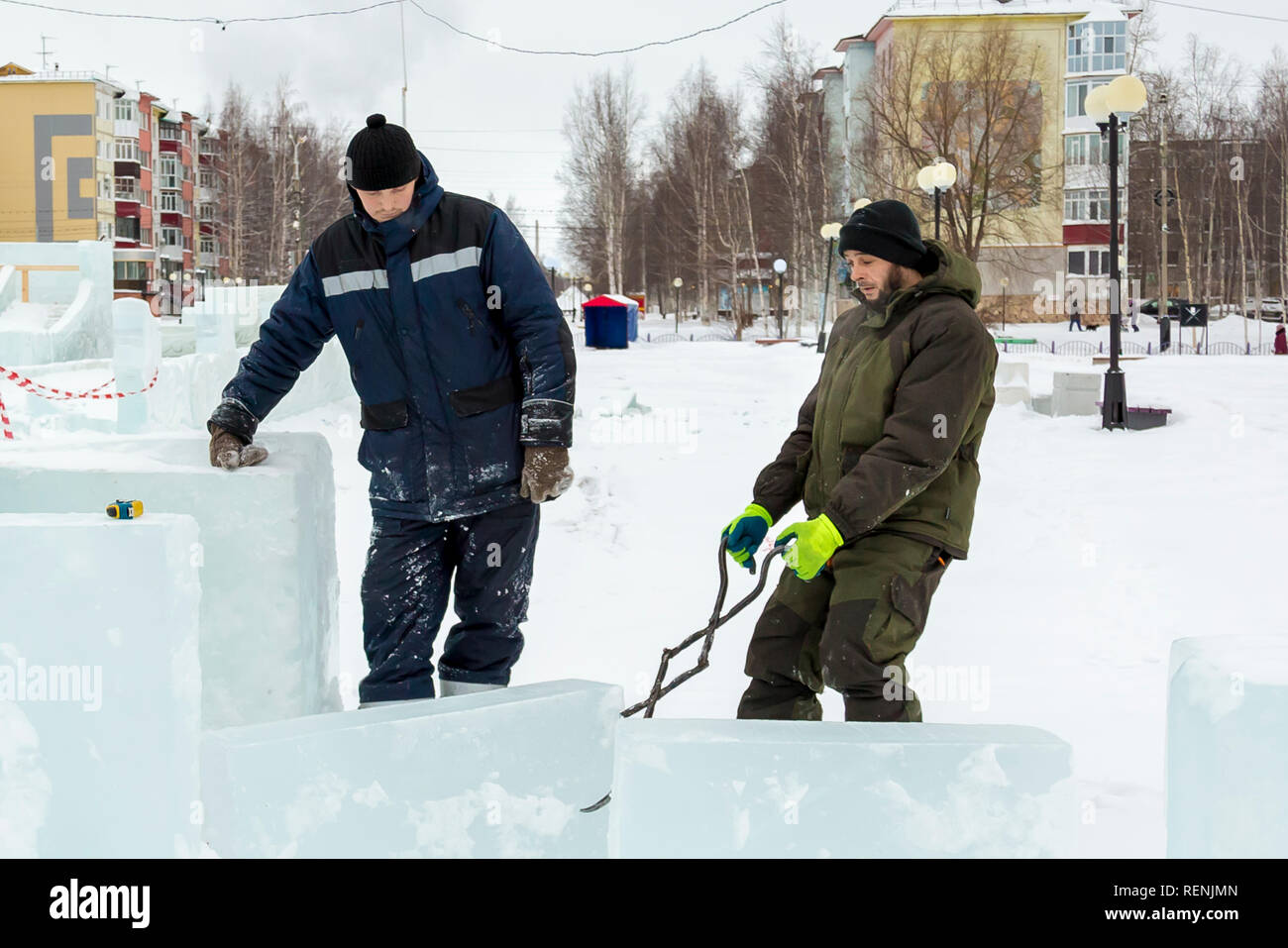 The worker pulls the ice block around the ice camp assembly site with ...