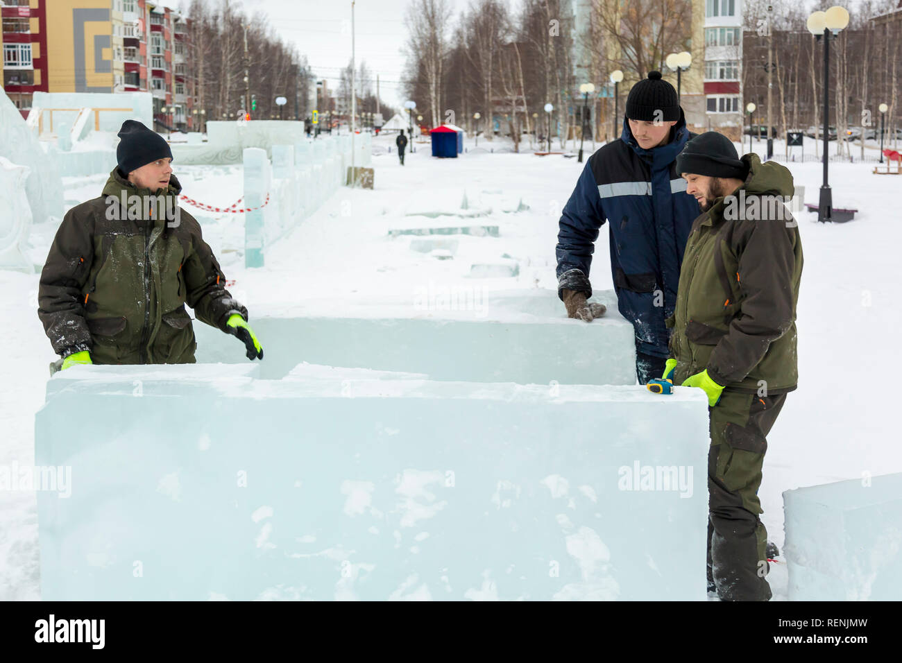 Workers assemblers mark the ice block on the construction site of the ...