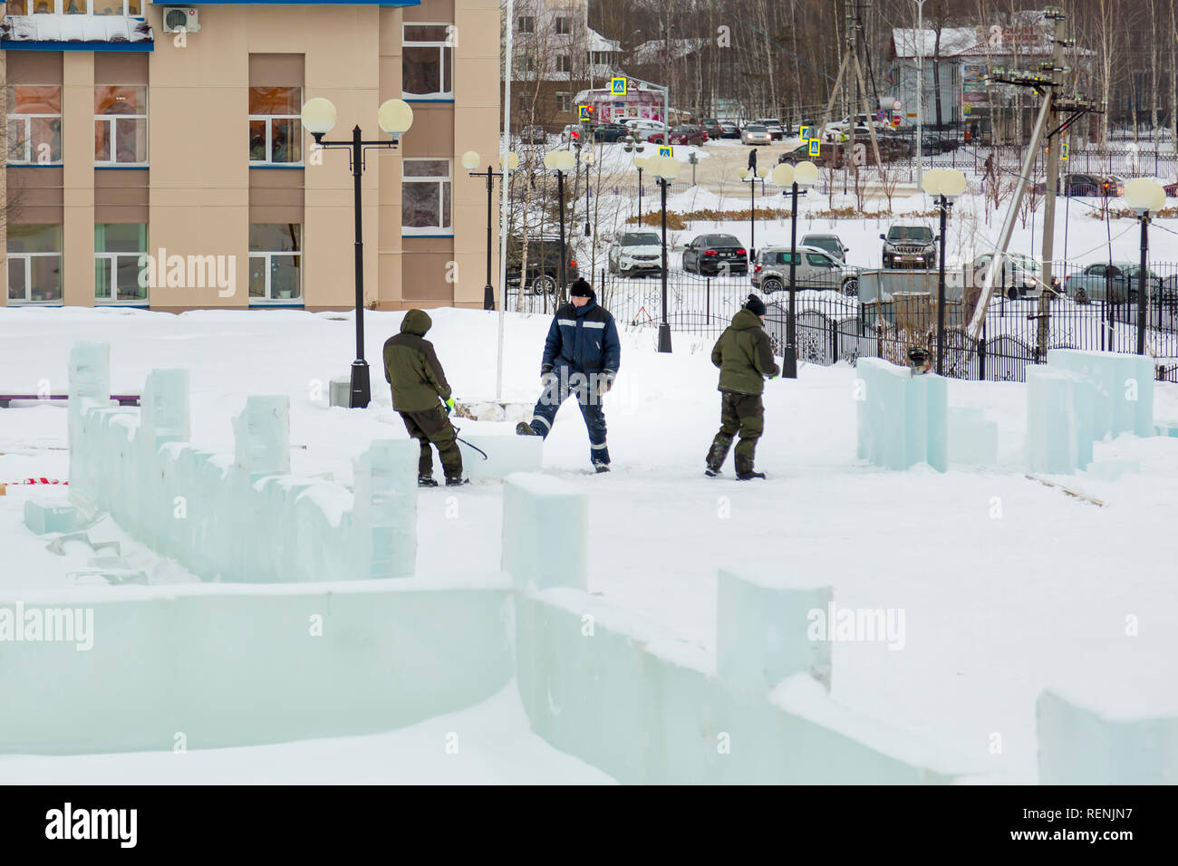 The worker pulls the ice block around the ice camp assembly site with ...