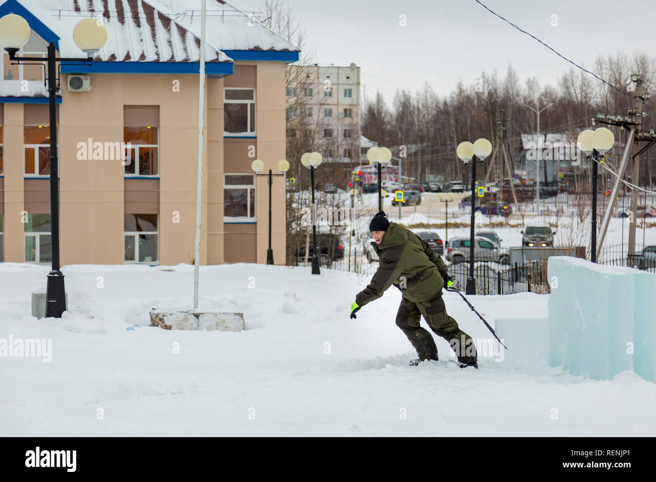 The worker pulls the ice block around the ice camp assembly site with ...