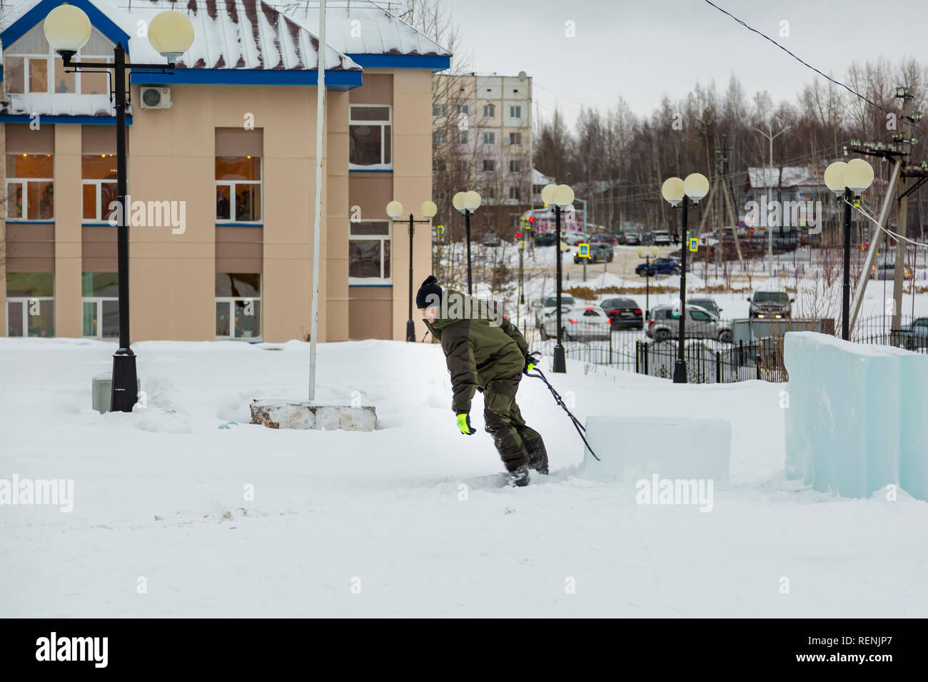 The worker pulls the ice block around the ice camp assembly site with ...