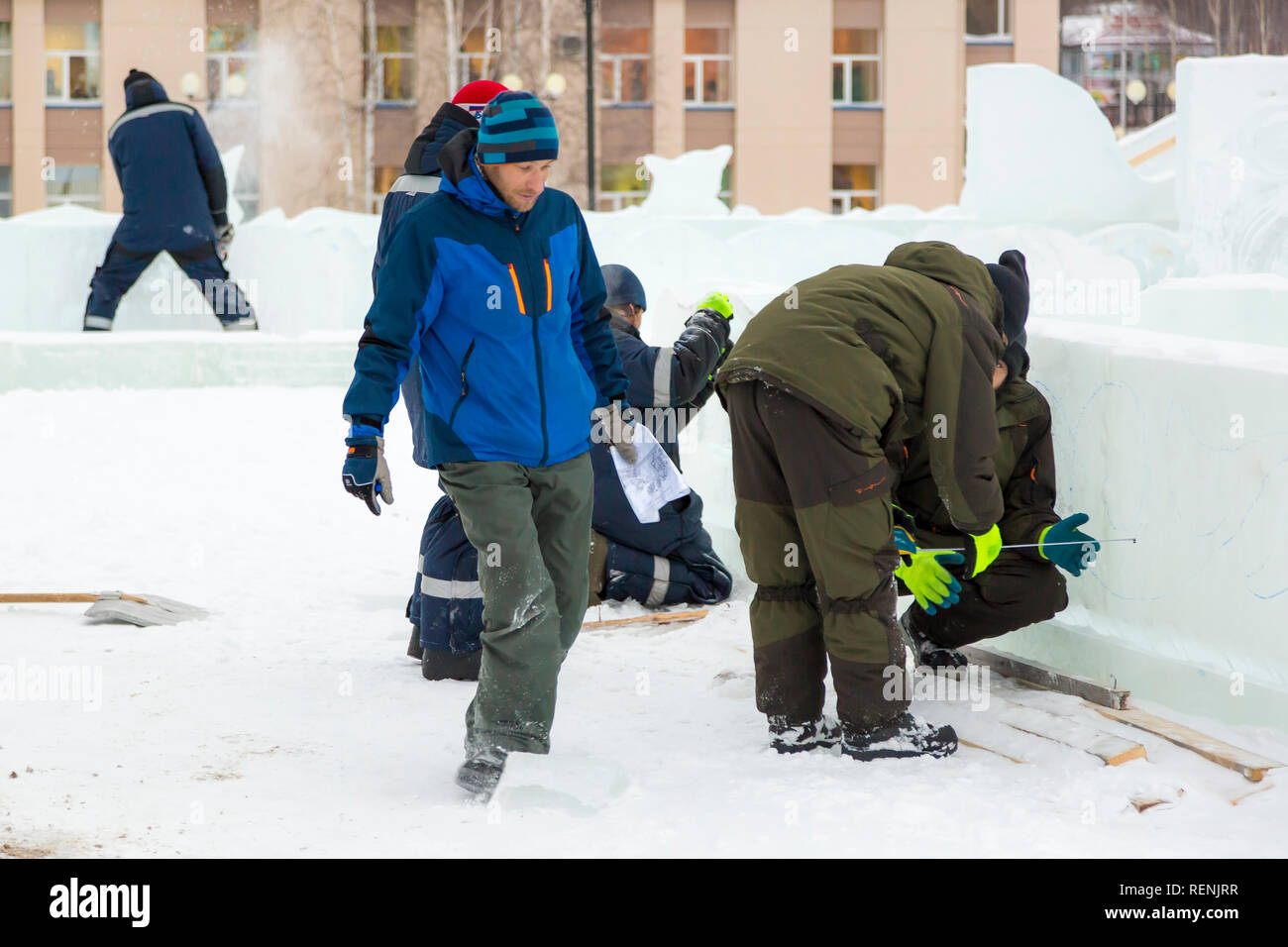Workers assemblers mark the ice block on the construction site of the ...