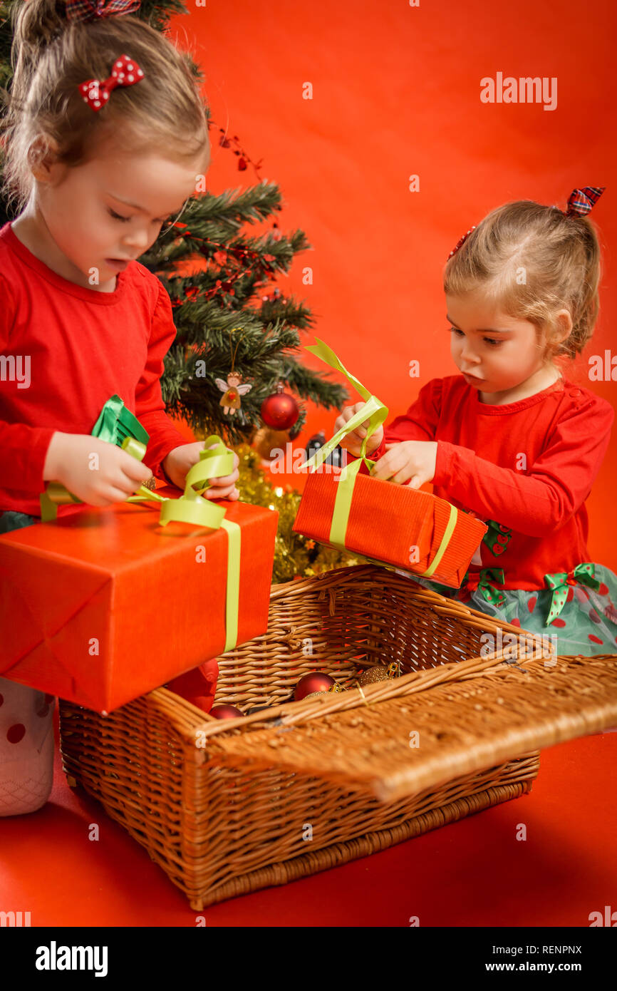 two little girls unpack their gifts in red boxes Stock Photo - Alamy