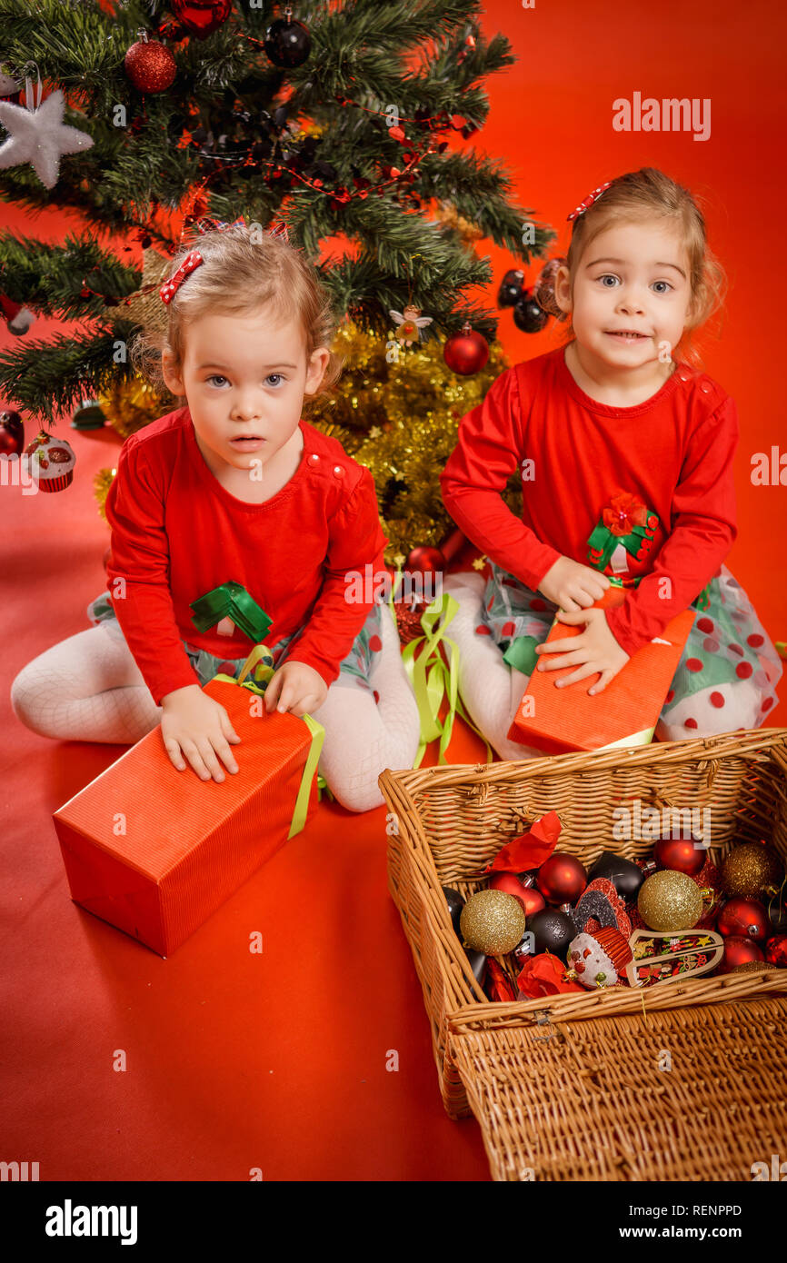 two little girls unpack their gifts in red boxes Stock Photo - Alamy