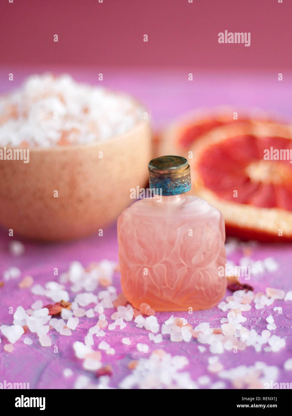 Close up photo of essential oil bottle and natural ingredients on pink ...