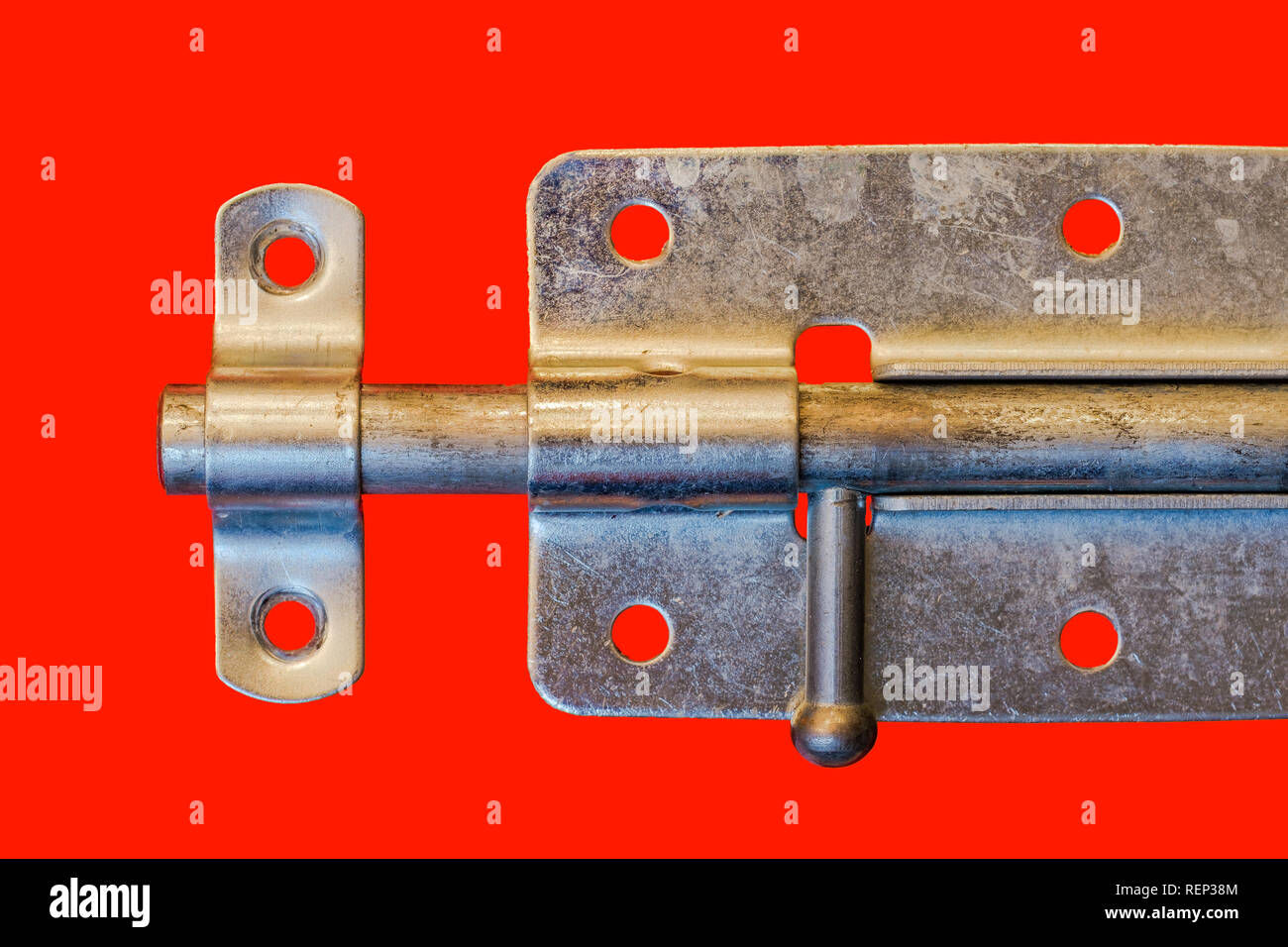 Steel door bolt, isolated on a red background Stock Photo - Alamy