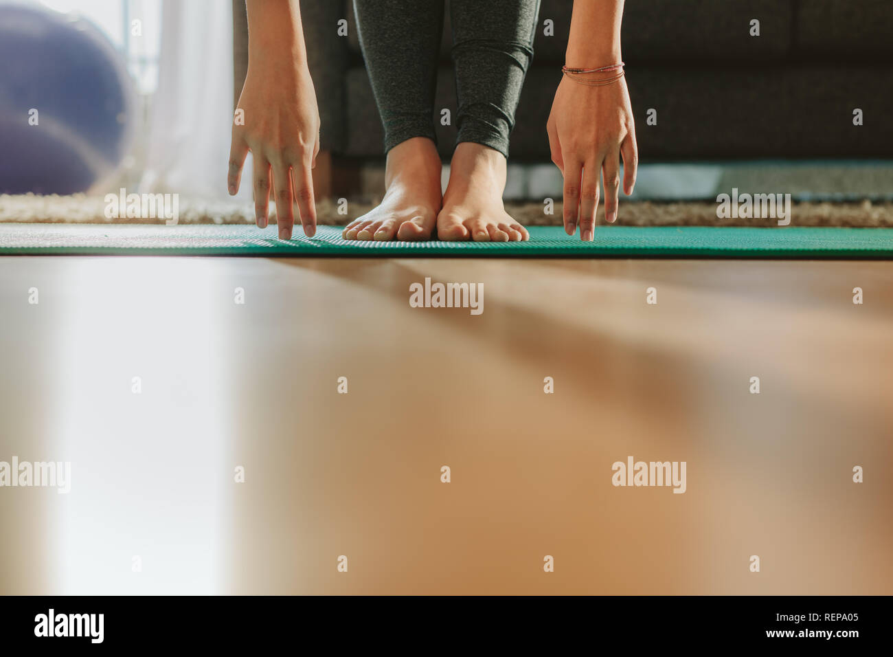 Low section view of female exercising indoors. Feet of women bending ...