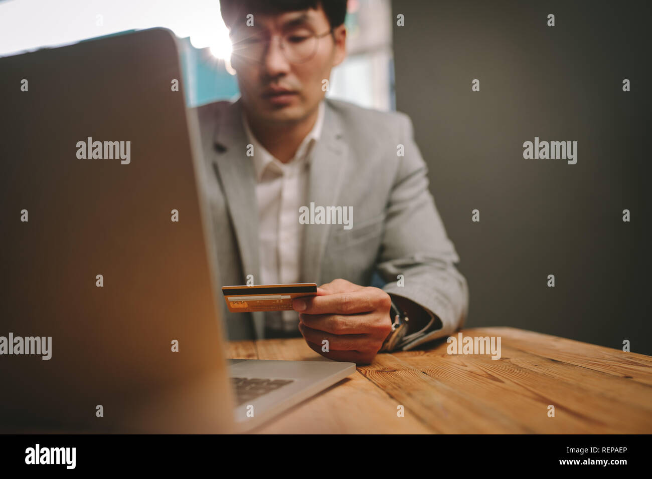 businessman sitting at table paying his bill online with credit card ...