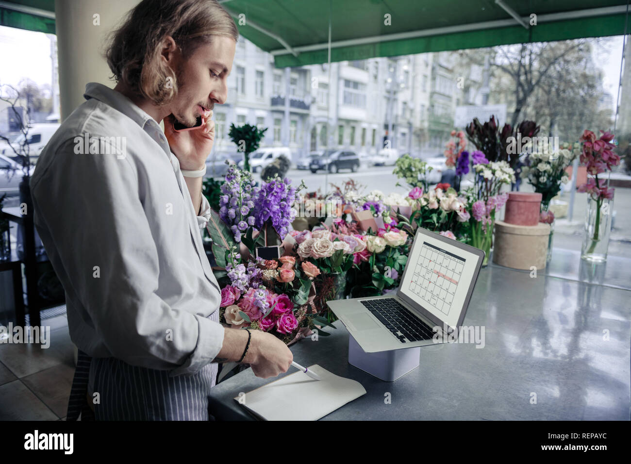 Serious shop assistant talking per telephone with partner Stock Photo ...