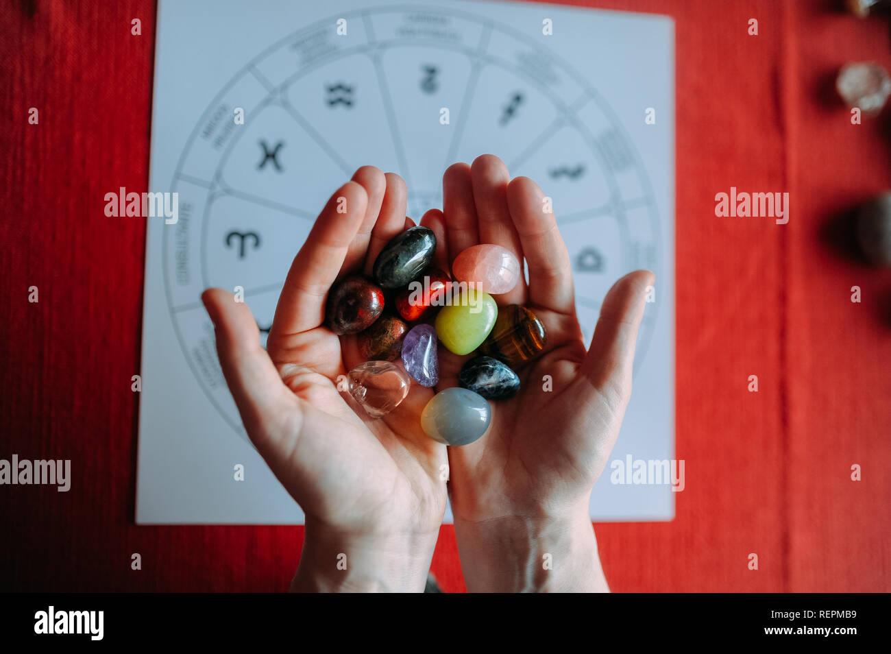 young woman hands showing group of colorful crystal stones during tarot ...