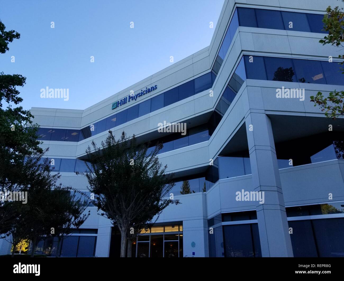 Low angle shot of the facade, sign, and logo at Hill Physicians, a ...
