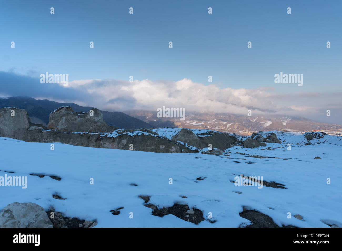 At a snowy mountain peak. Half of Mountain range covered with snow ...