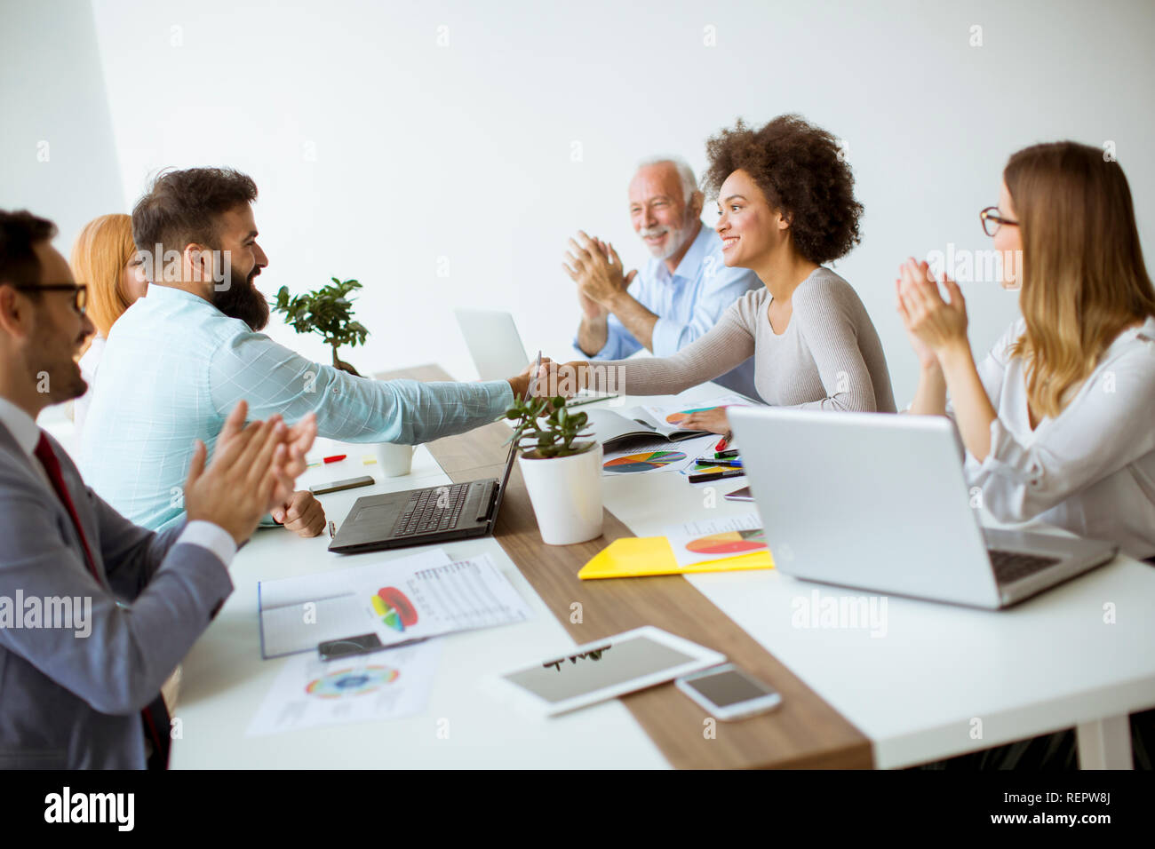 Business people shaking hands iin office while finishing up a meeting ...