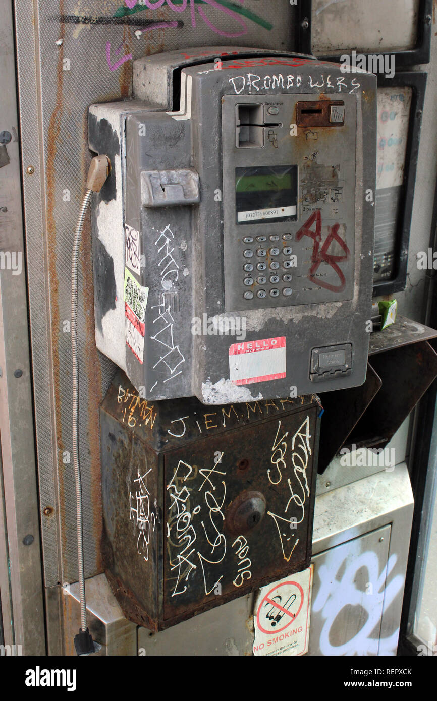 Vandalised phone dangling from phone cabin, Brighton, UK Stock Photo ...