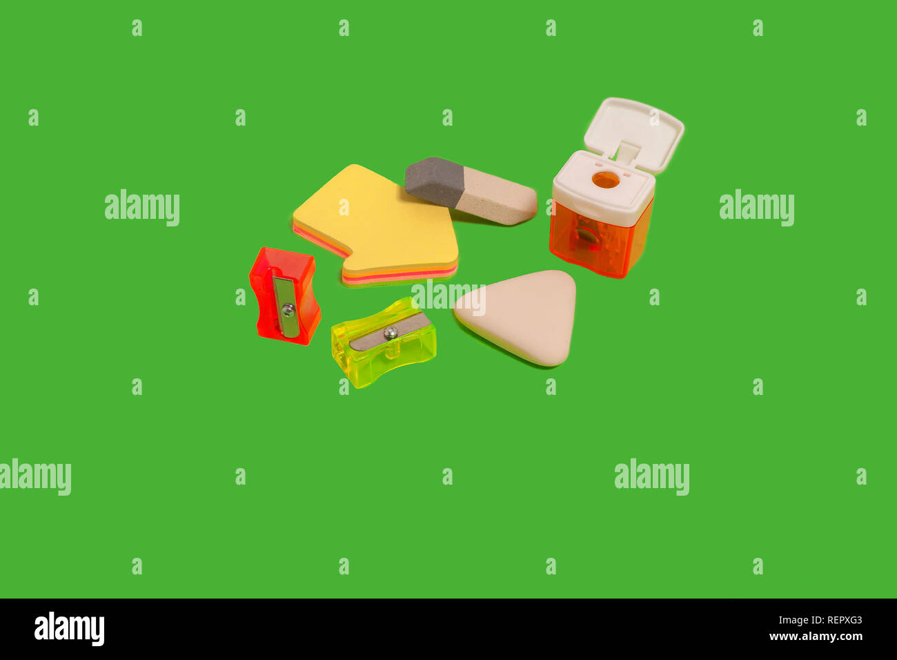 different erasers and sharpeners on a green surface Stock Photo - Alamy