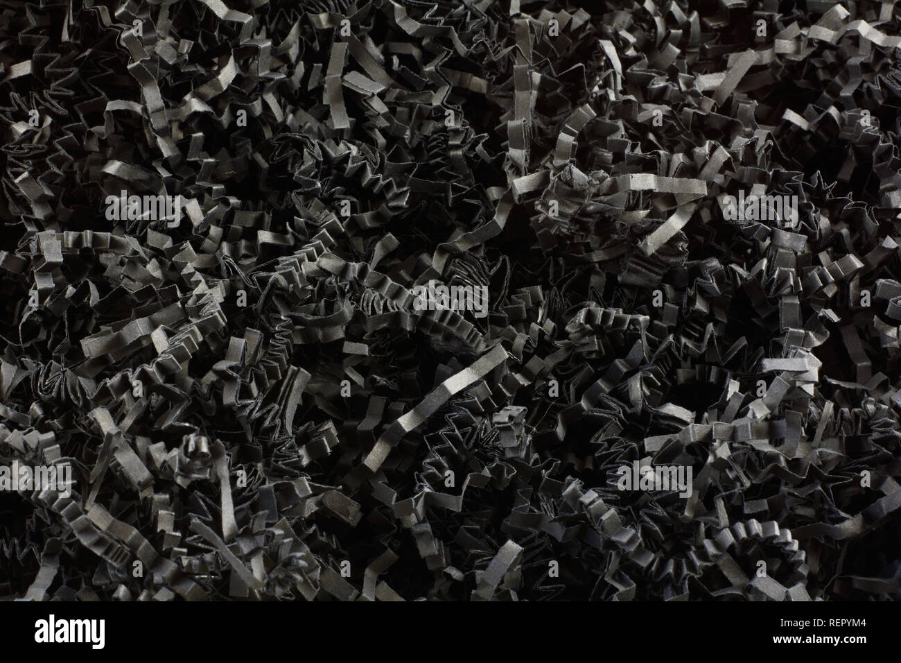 Close up of crinkled shredded black paper box filler for shipping ...