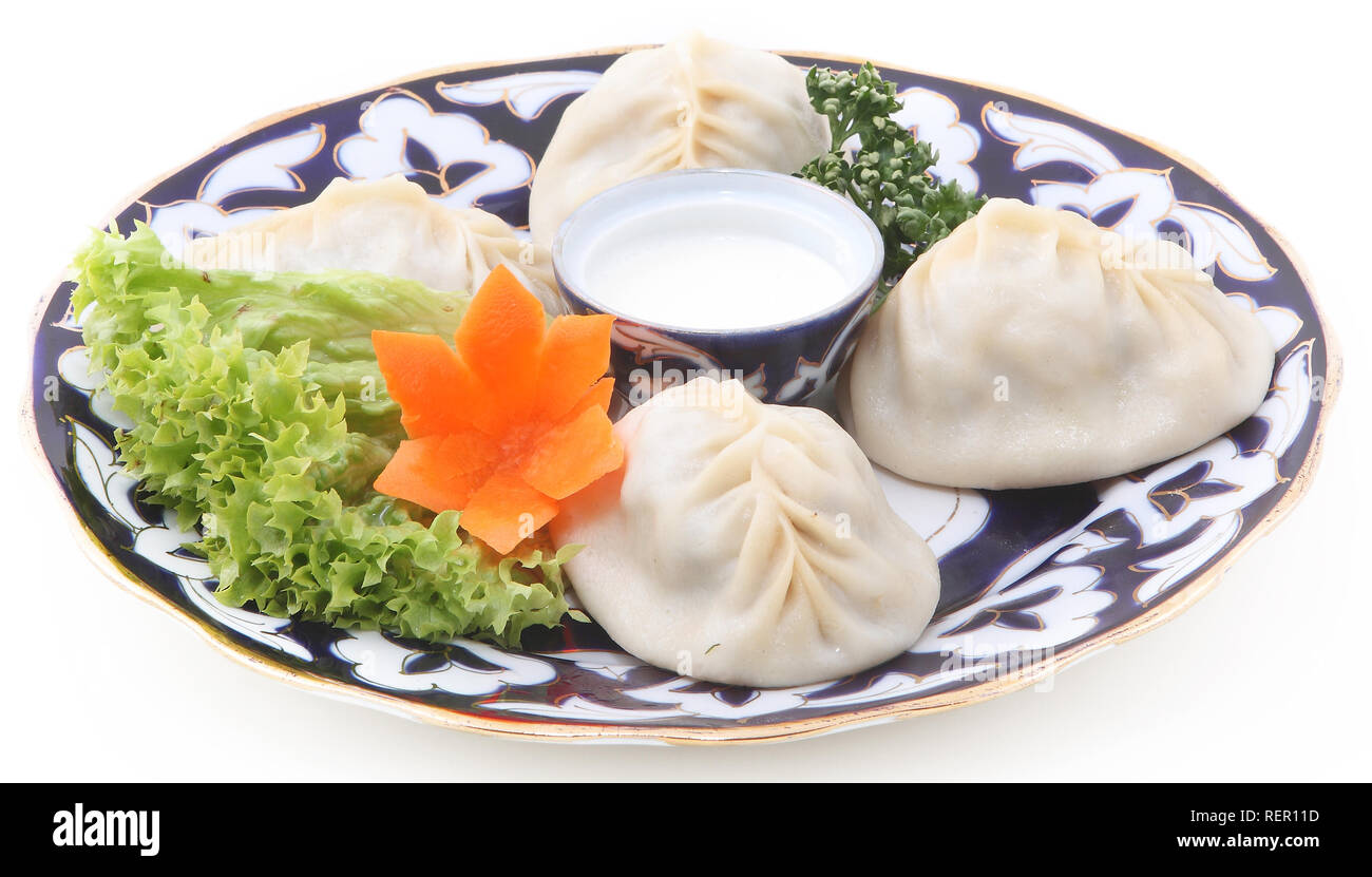 Uzbek manti with sour cream and herbs on a plate with an oriental ...