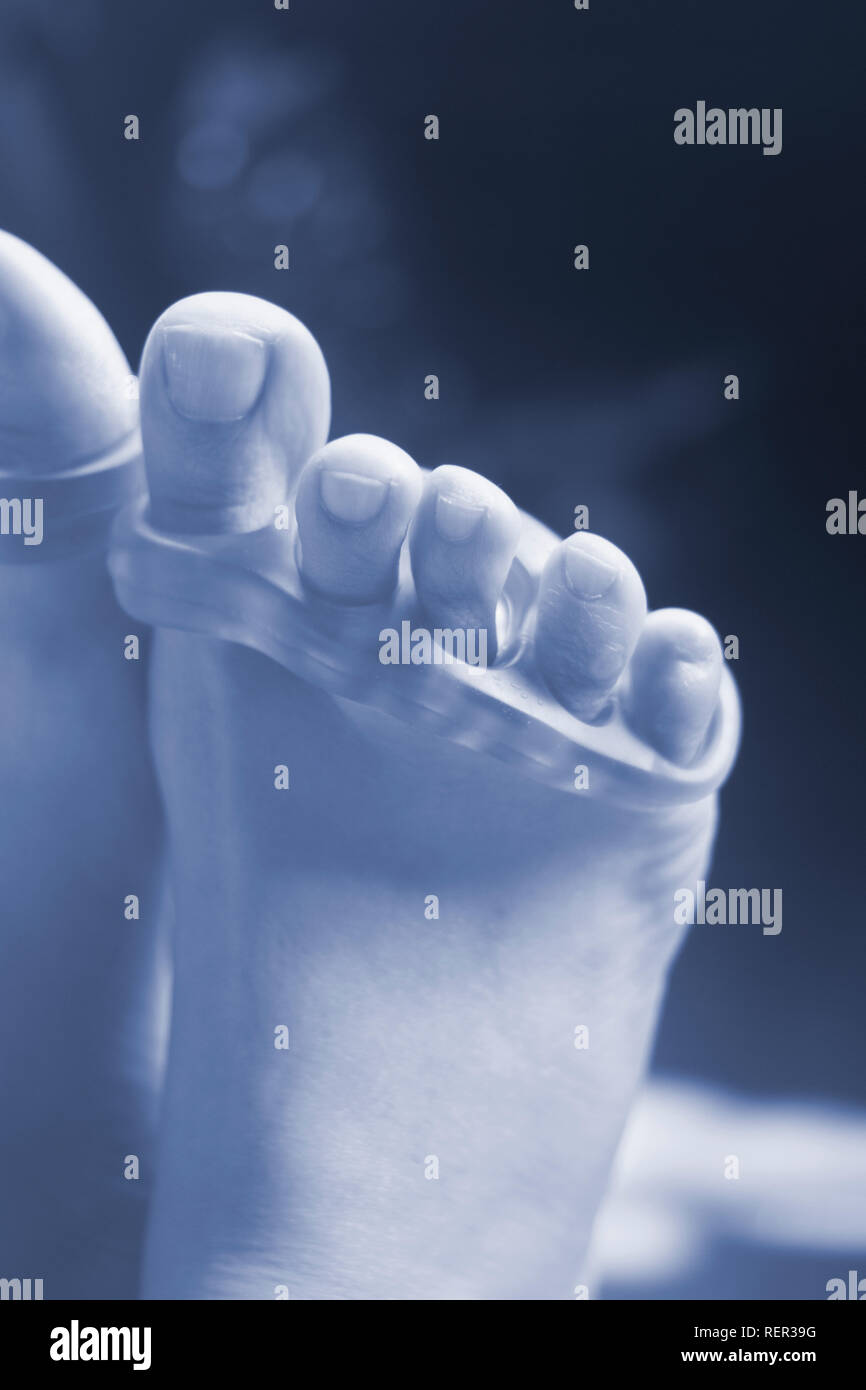 Young woman with silicone toe separator to separate toes to pedicure ...