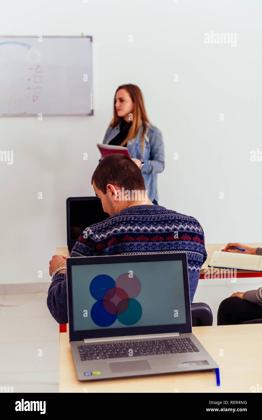 Female student is having a presentation on the board while the other ...