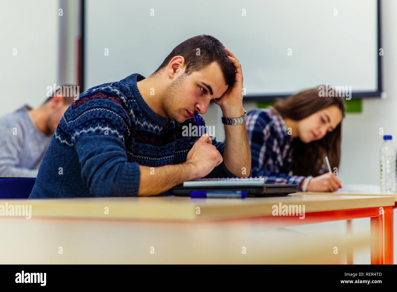 Group of young students writing notes in the classroom Stock Photo - Alamy