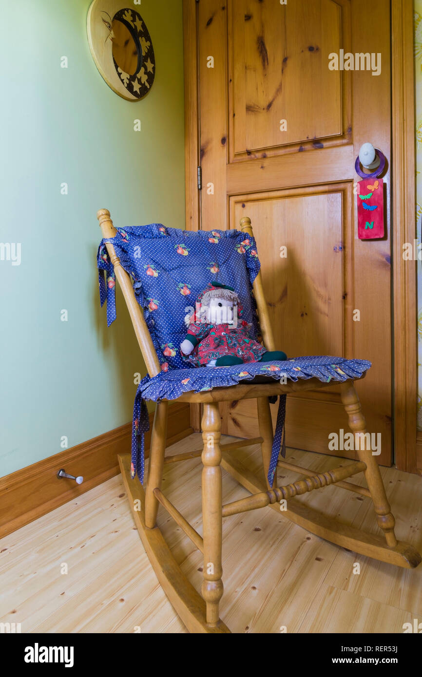 Antique wooden rocking chair with blue cushions and a ragdoll in ...
