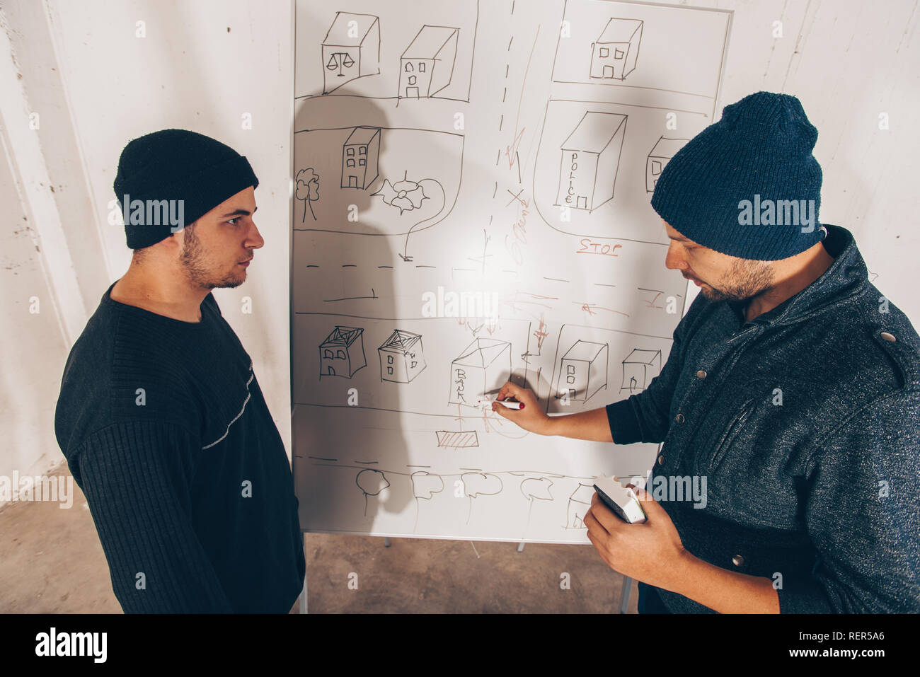 Thiefs standing and drawing a map for robbery Stock Photo - Alamy