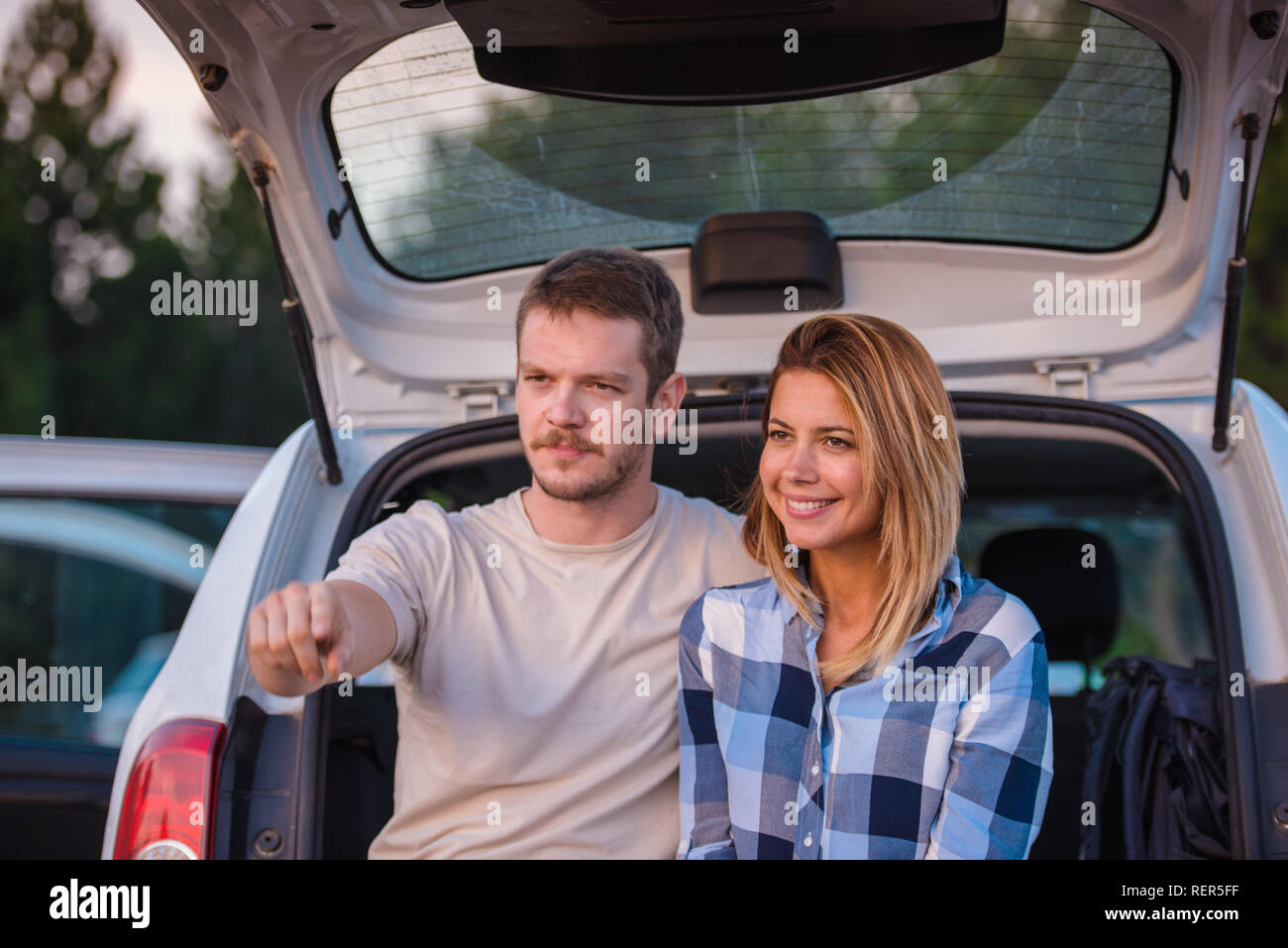 Young couple sitting on the back of a off road vehicle and enjoying the ...