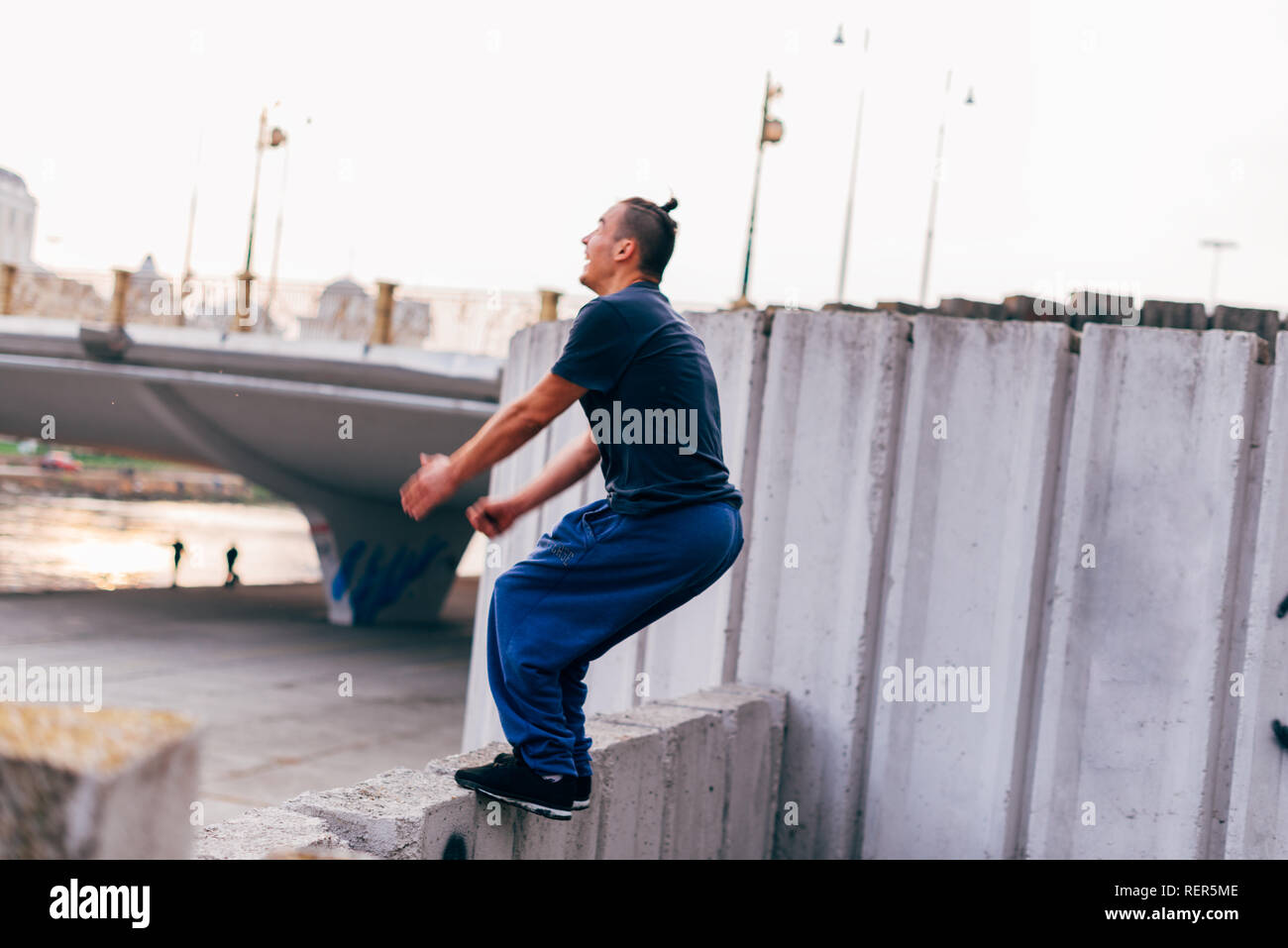 Free runner training parkour jumping on a fence while doing a back flip ...