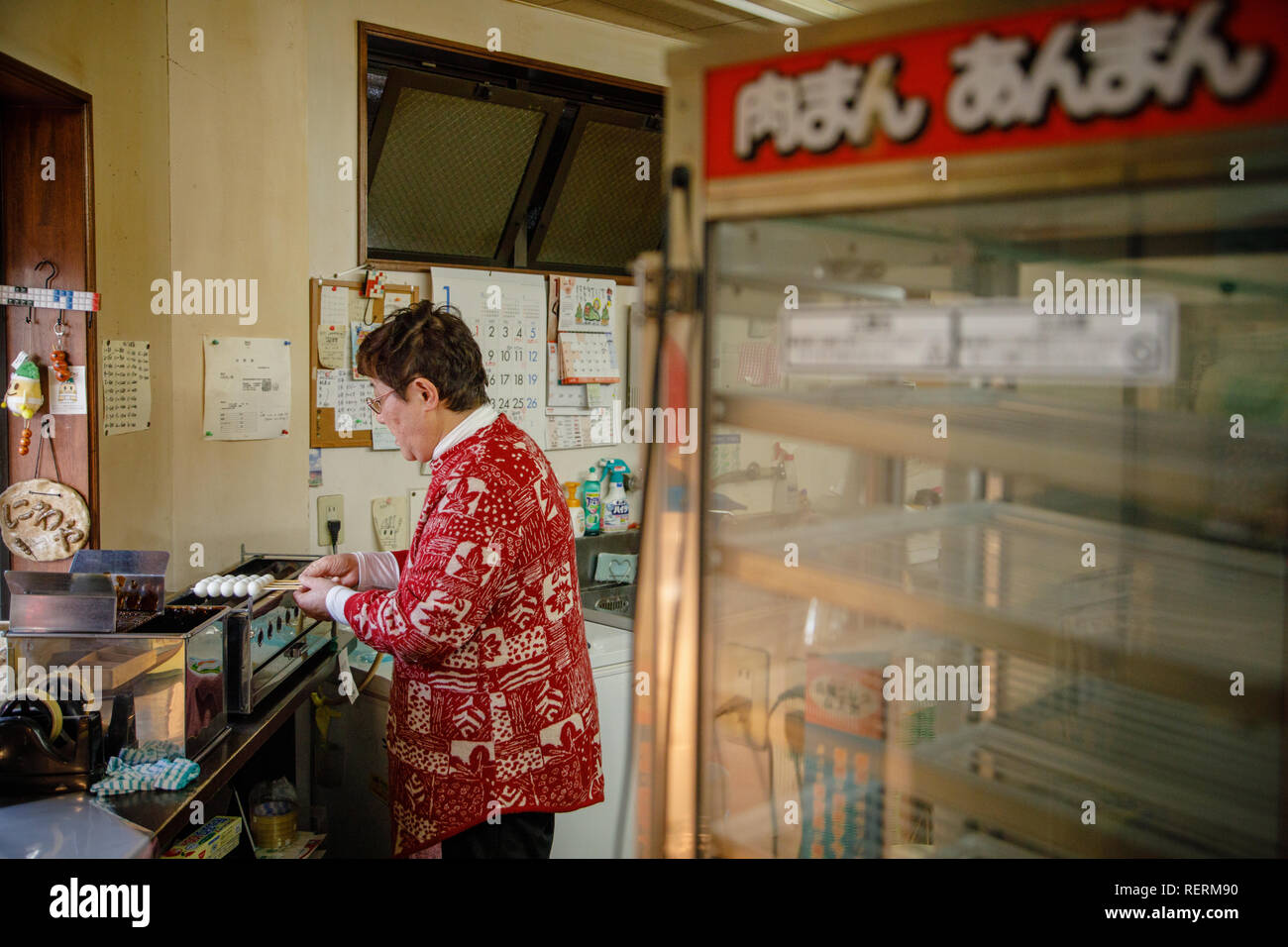 A woman seen making Japanese sweet rice dumpling ball “Mitarashi dango ...