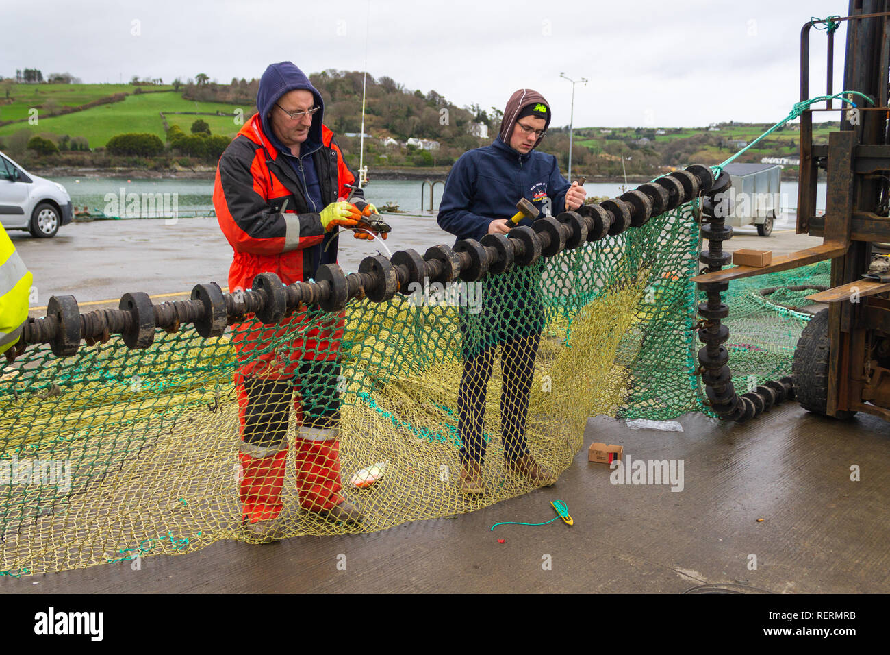 2 fishermen repairing a prawn net on the quay in Union Hall West Cork ...