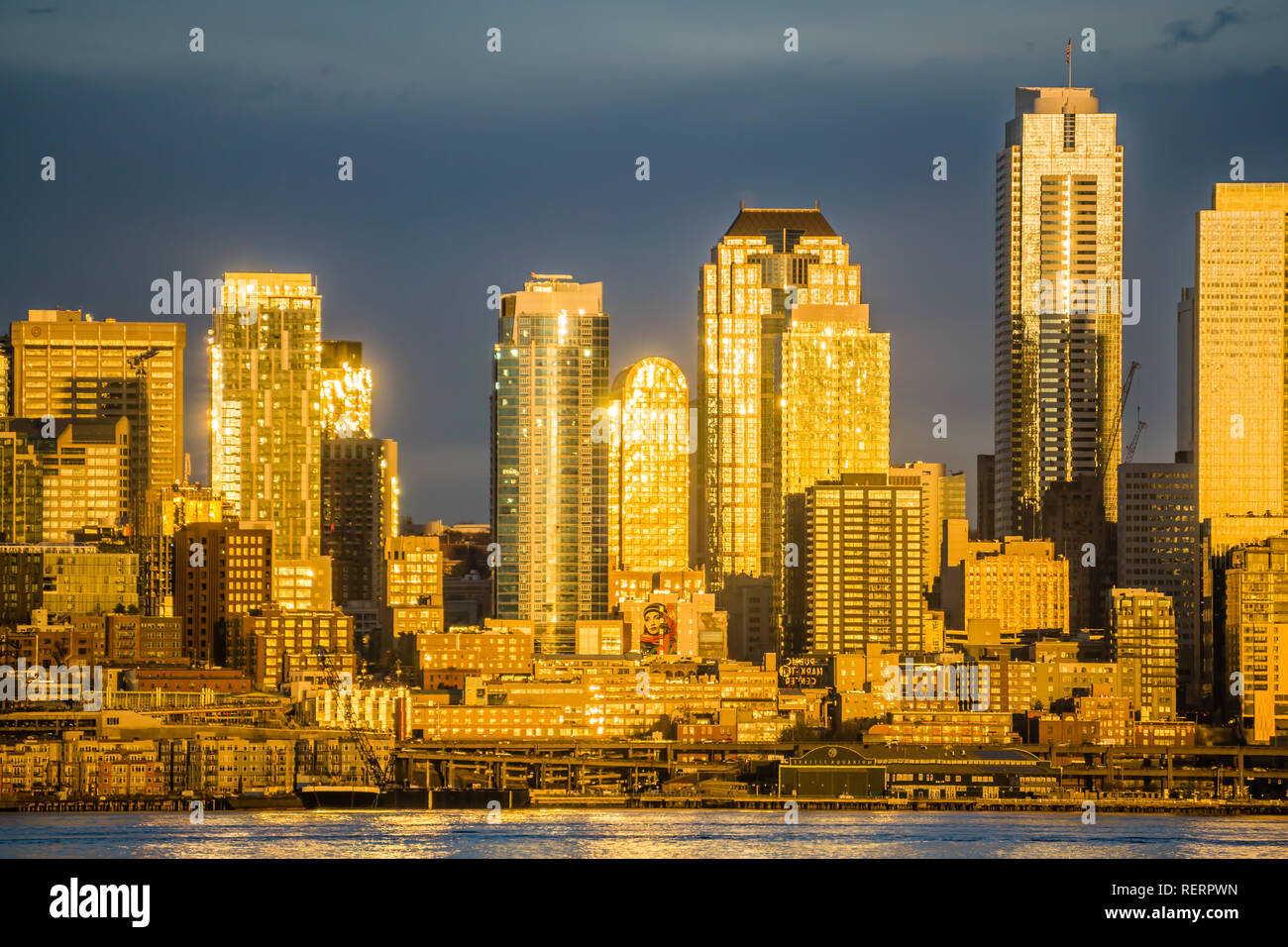 The setting sun is reflected from the skyscrapers in the Seattle ...