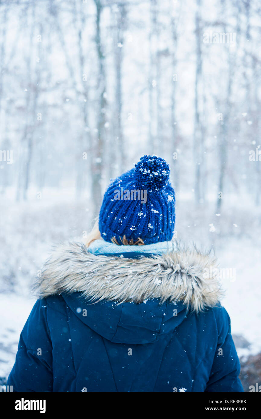 woman with blue winter coat and hat under snow in nature Stock Photo ...