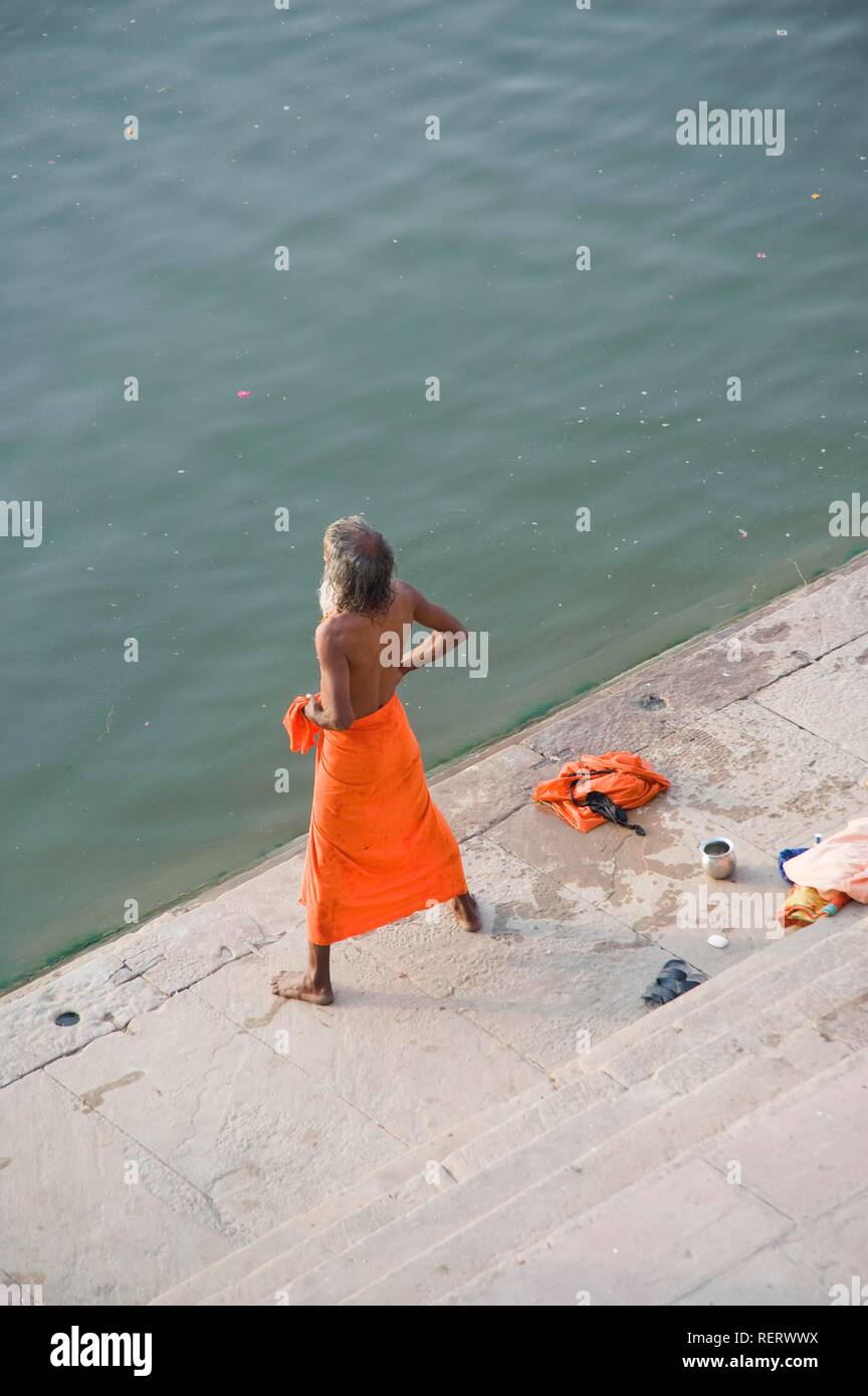 Indian man doing the traditional morning ablution at the ghats ...
