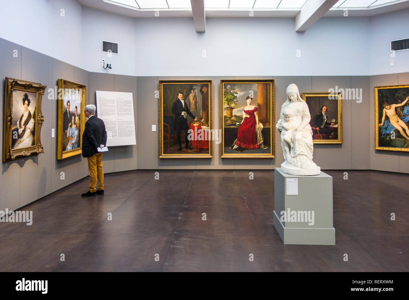 Visitor looking at 19th century Neoclassical paintings in the ...