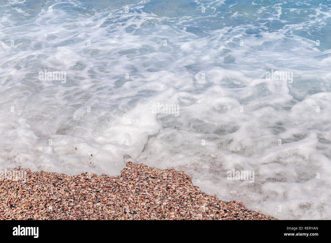 Close up bubbles waves blue sea water on sand beach Stock Photo - Alamy