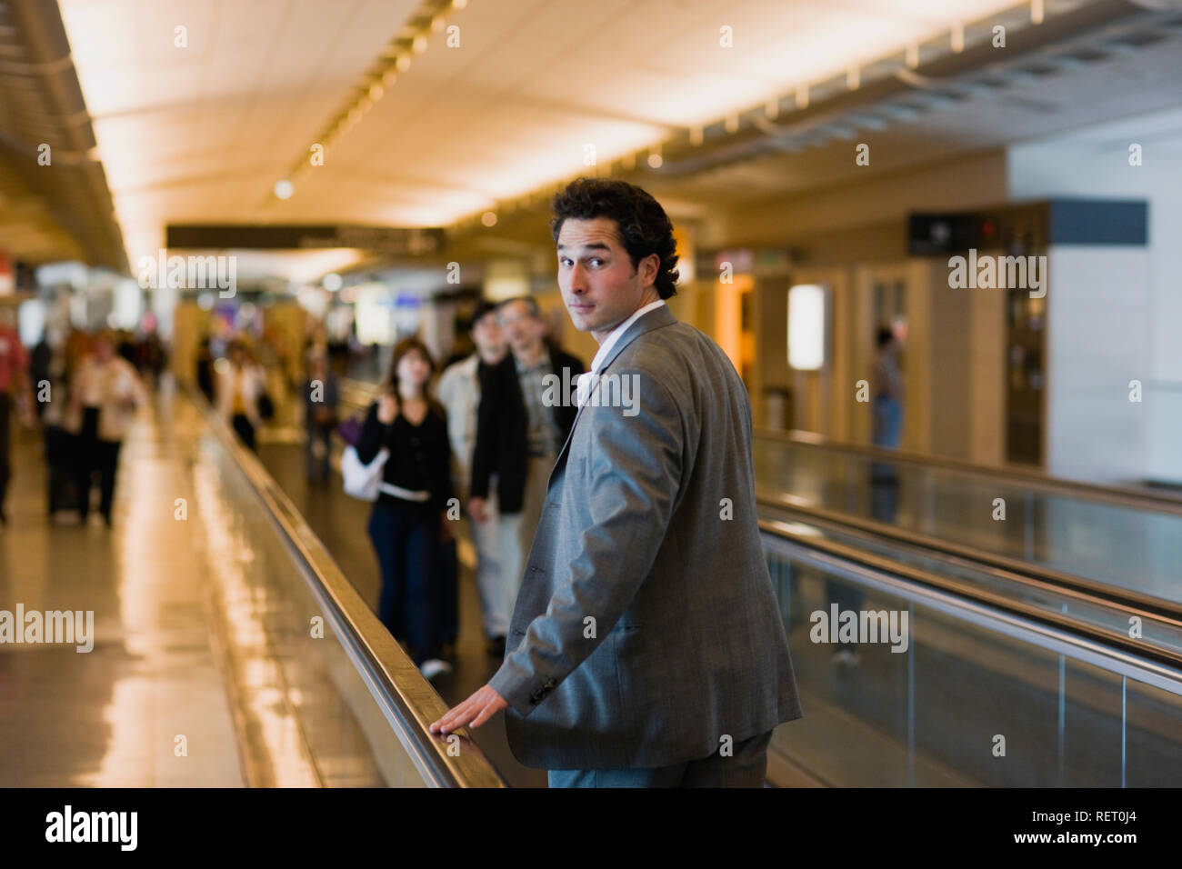 Portrait of a young businessman looking over his shoulder while riding ...