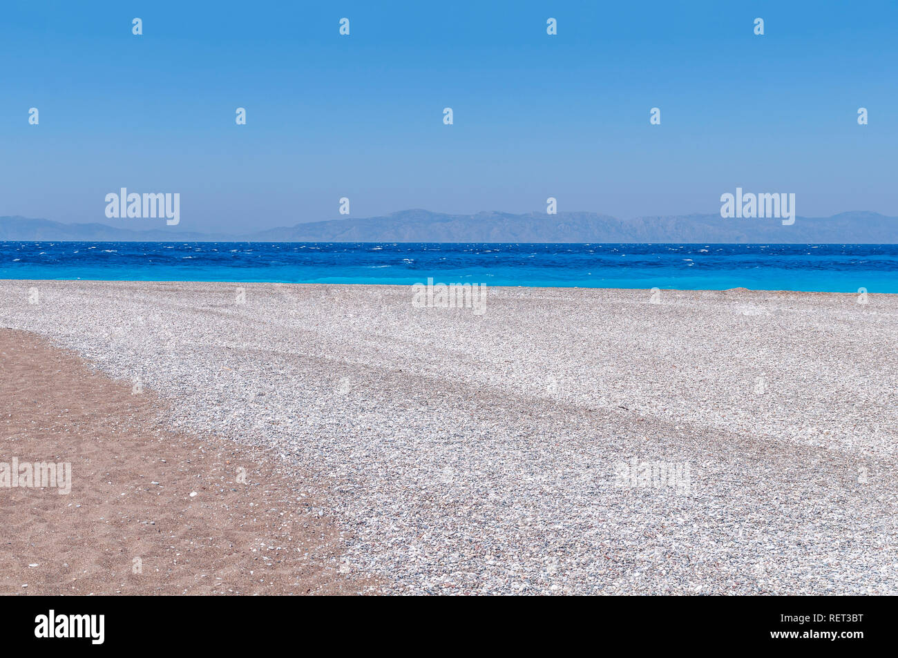 Pebble sandy beach with blue and clean sky Stock Photo - Alamy