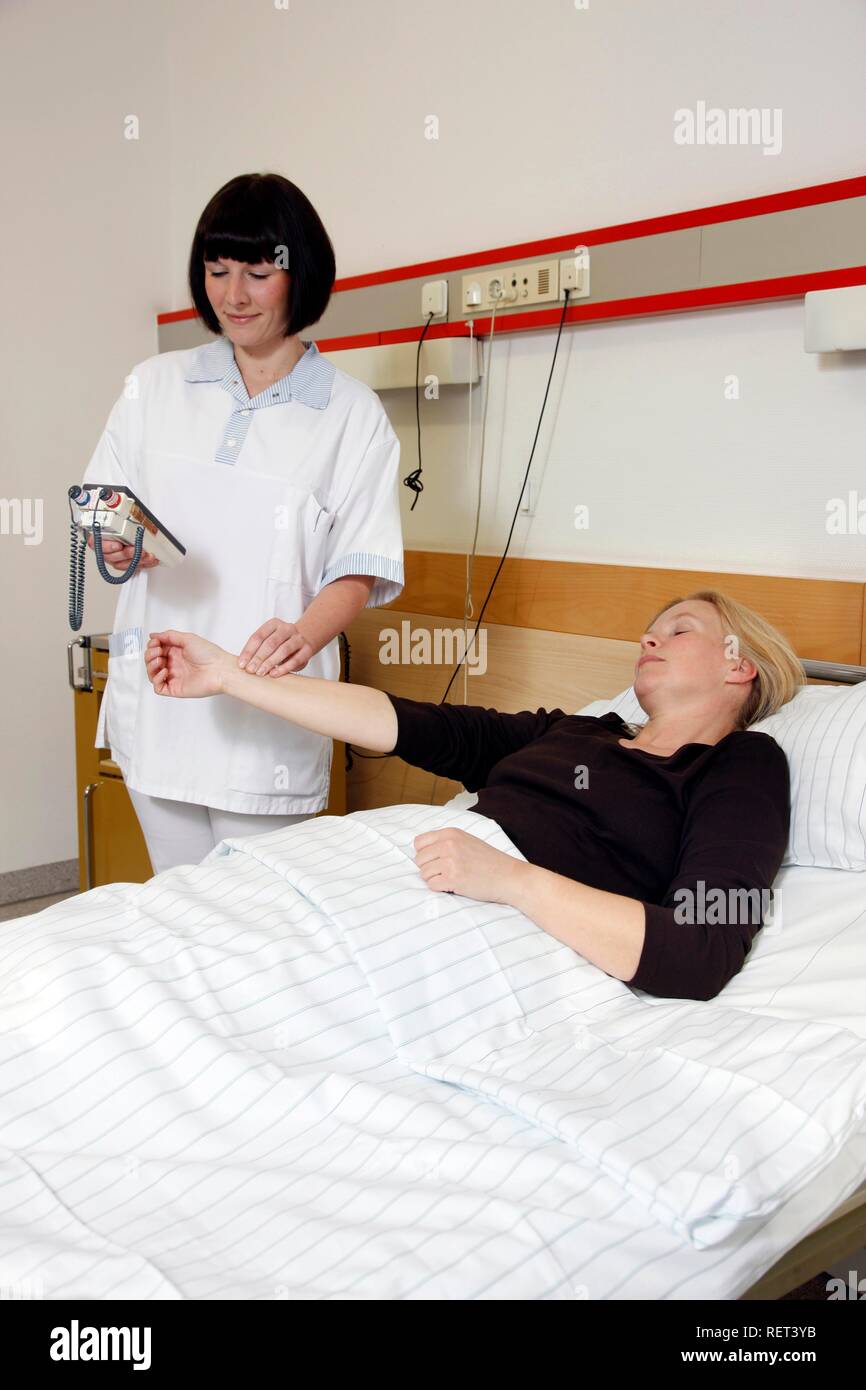 Nurse checking the pulse of a patient in a hospital Stock Photo - Alamy