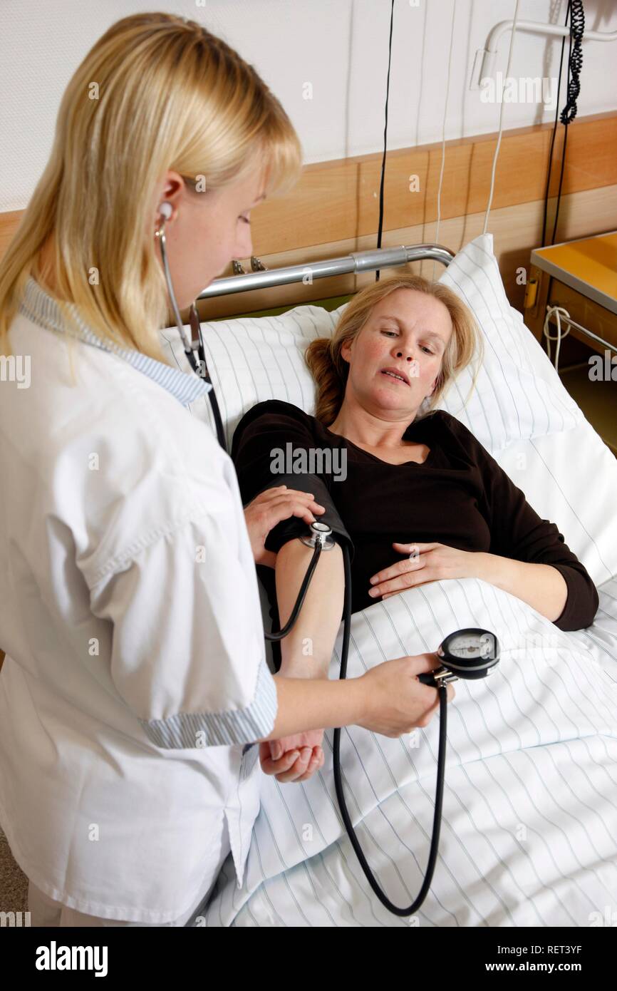 Nurse checking the blood pressure of a patient in a hospital Stock ...