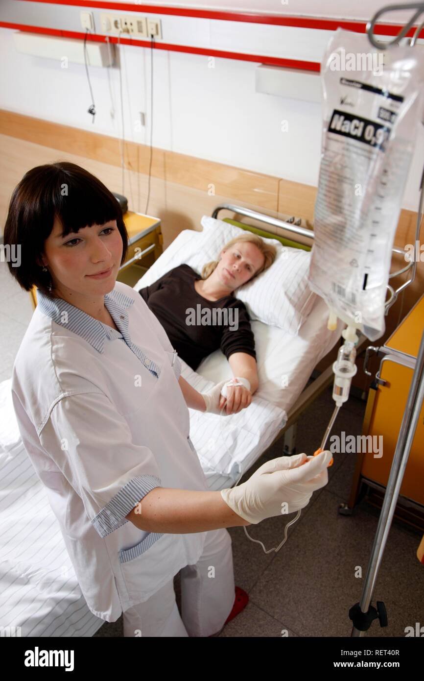 Nurse in a hospital setting up an infusion for a patient Stock Photo ...