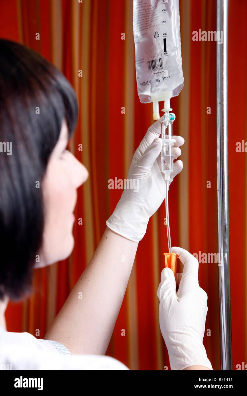 Nurse in a hospital setting up an infusion for a patient Stock Photo ...