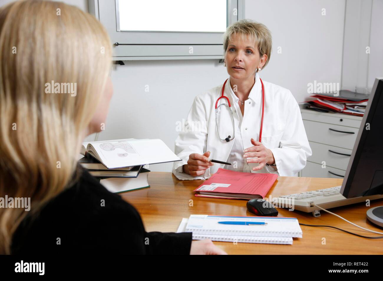 A female doctor talking to patient in a hospital doctor's office Stock ...
