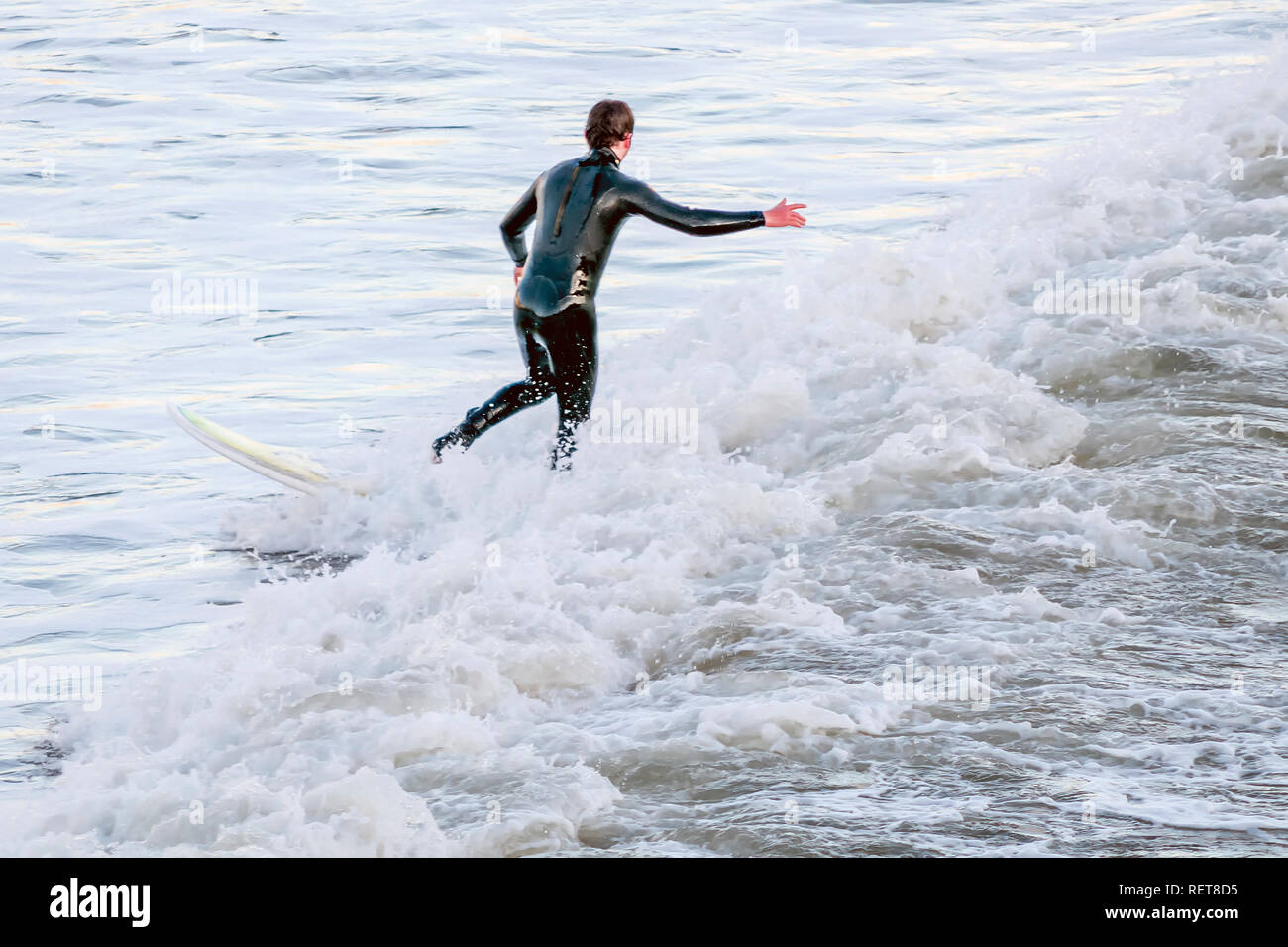 Surfer balancing on the surfboard in the middle of the sea waves Stock ...