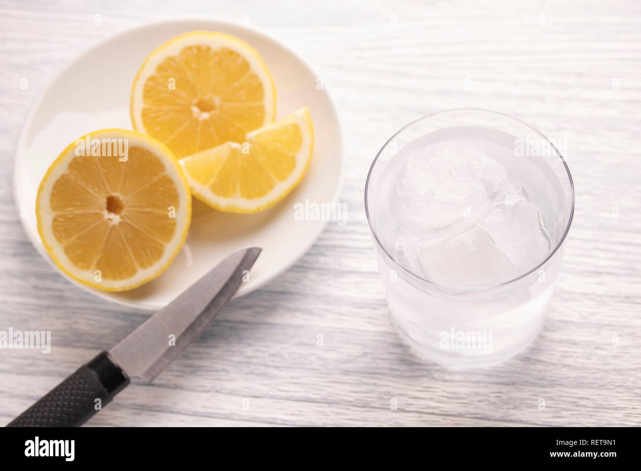 Refreshing cold water with lemon in a steaming glass with ice. On a ...
