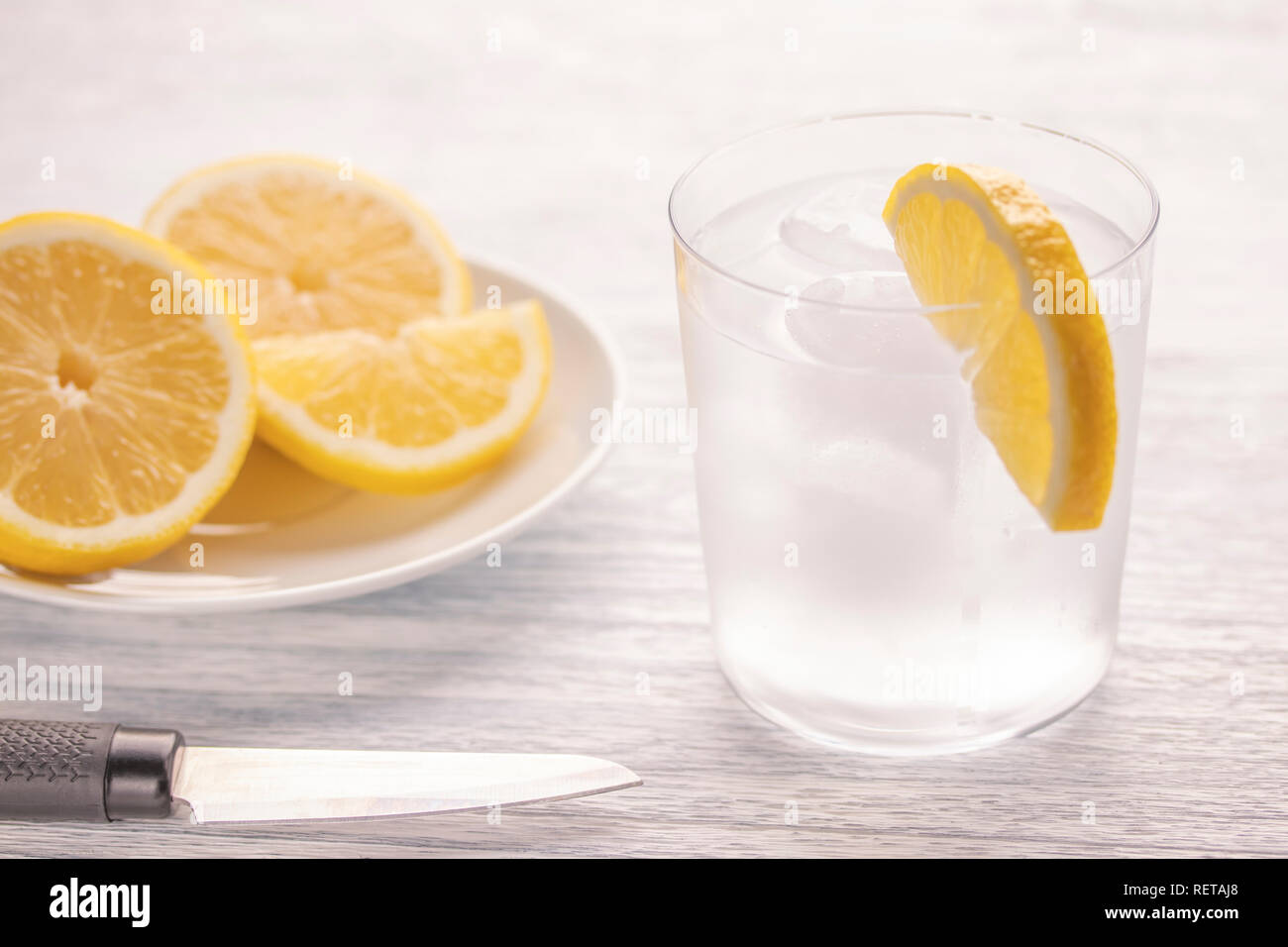 Refreshing cold water with lemon in a steaming glass with ice. On a ...