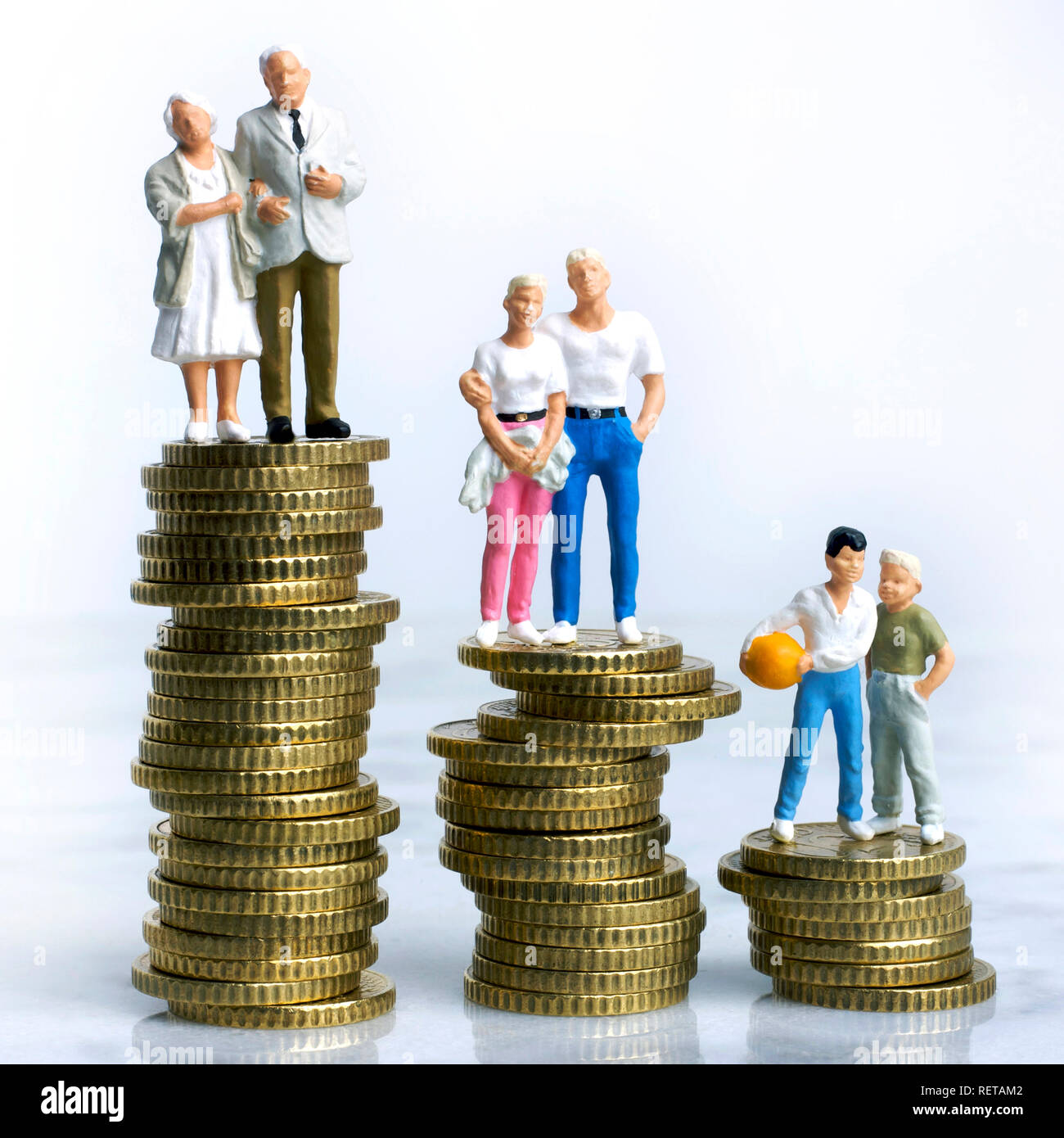 Symbol picture, finances, family, figurines sitting on stack of coins ...