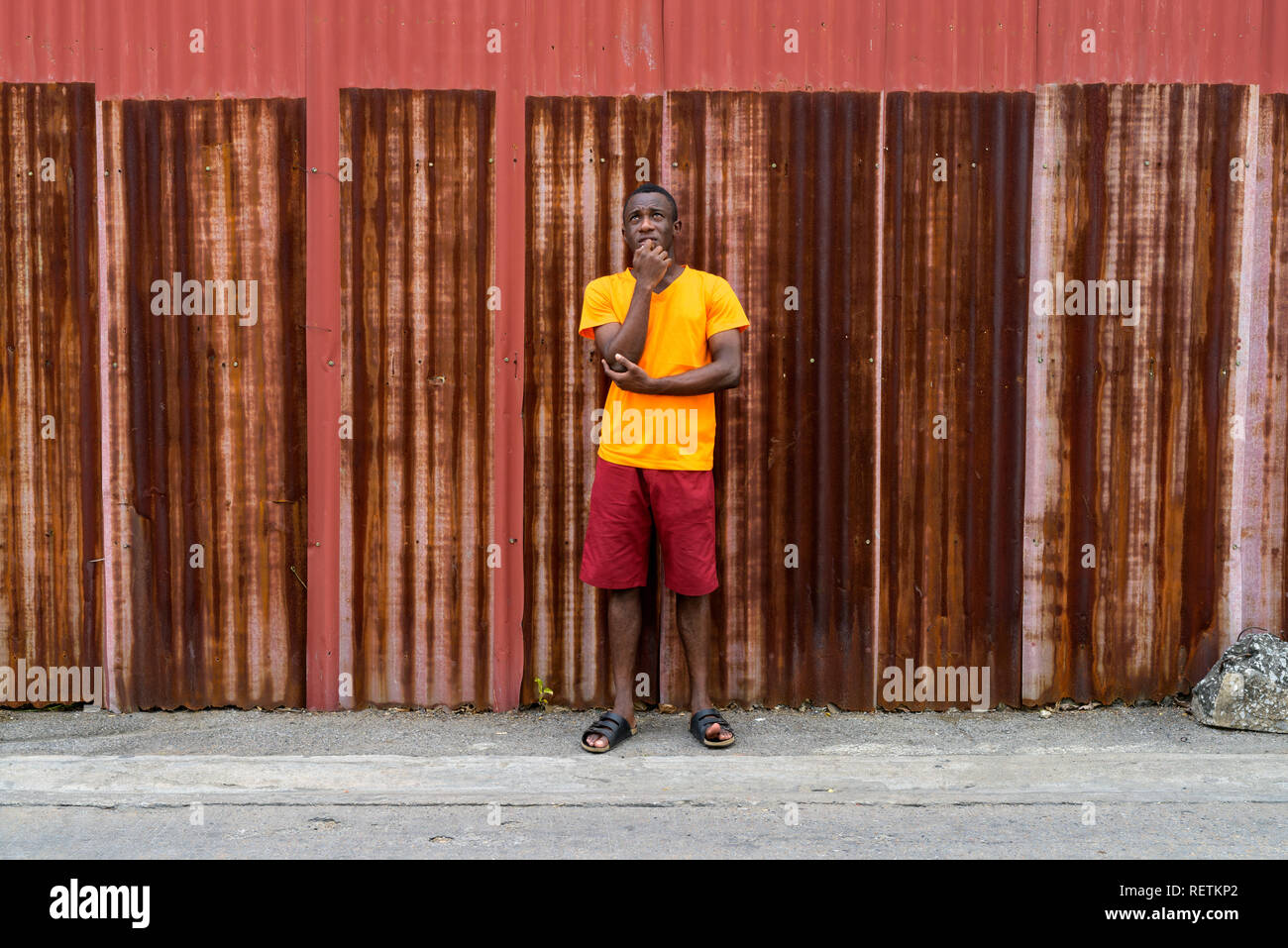 Young black African man standing while thinking against old rust Stock ...