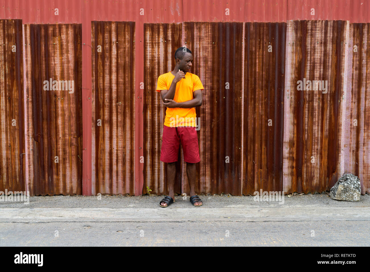 Young black African man thinking and looking down while standing Stock ...
